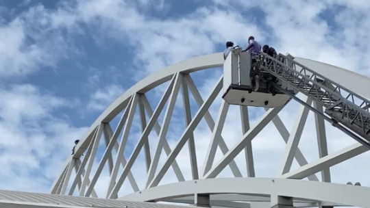 Suspended Firefighter Climbs Down From Top Of Half Way Tree Transport ...